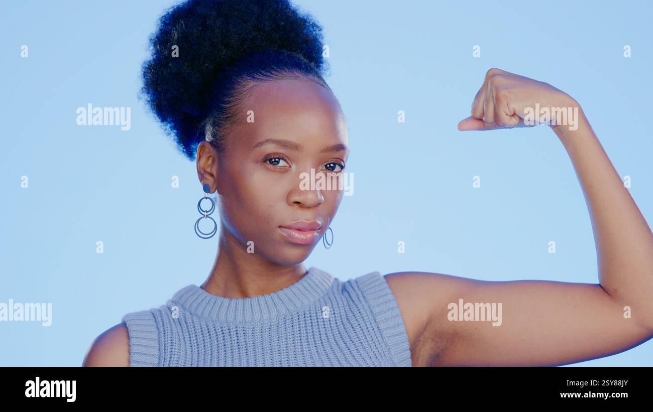 Strong, muscle and face of a black woman with biceps isolated on a blue ...
