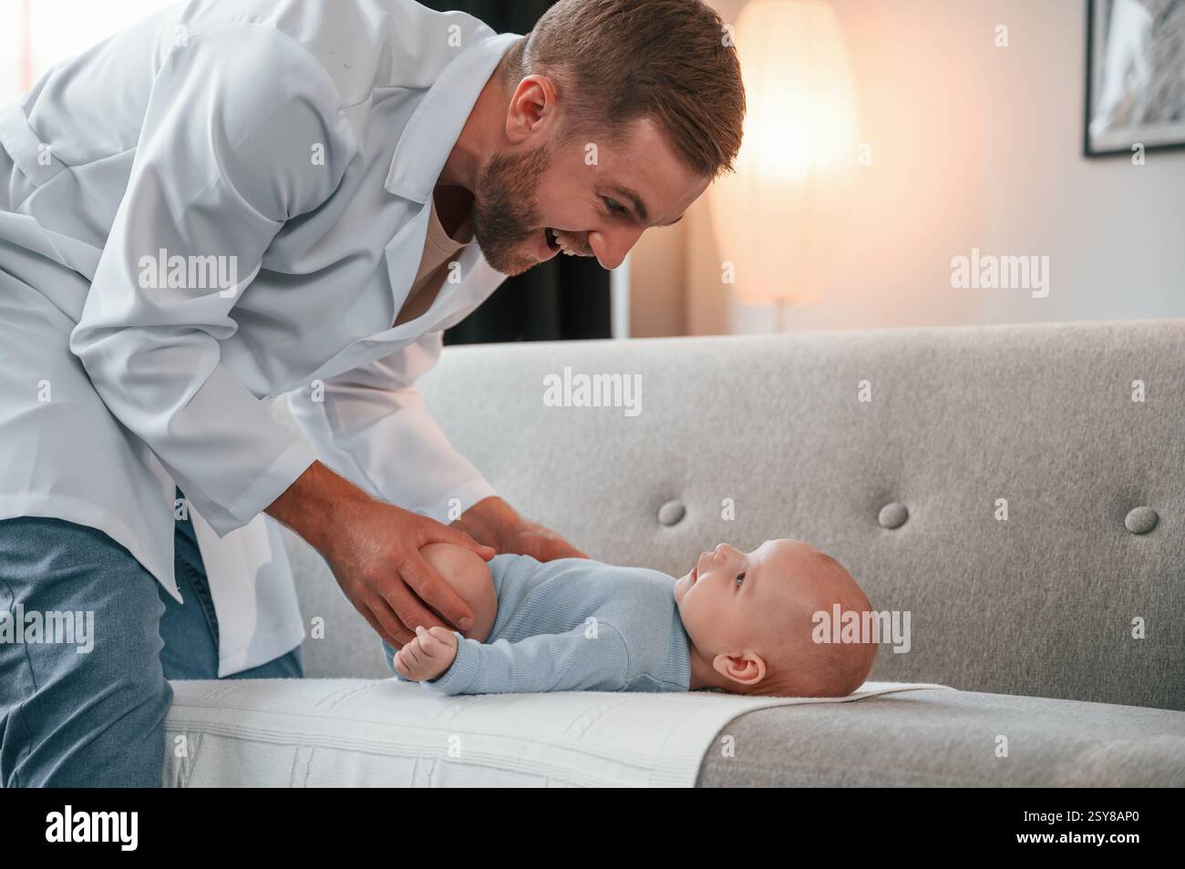 Professional doctor is taking care of newborn baby indoors in apartment ...