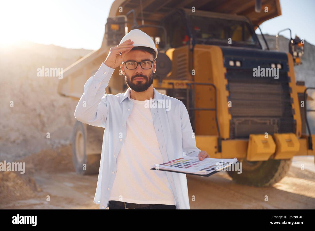Big haul track behind. Man in uniform is working in the quarry at ...