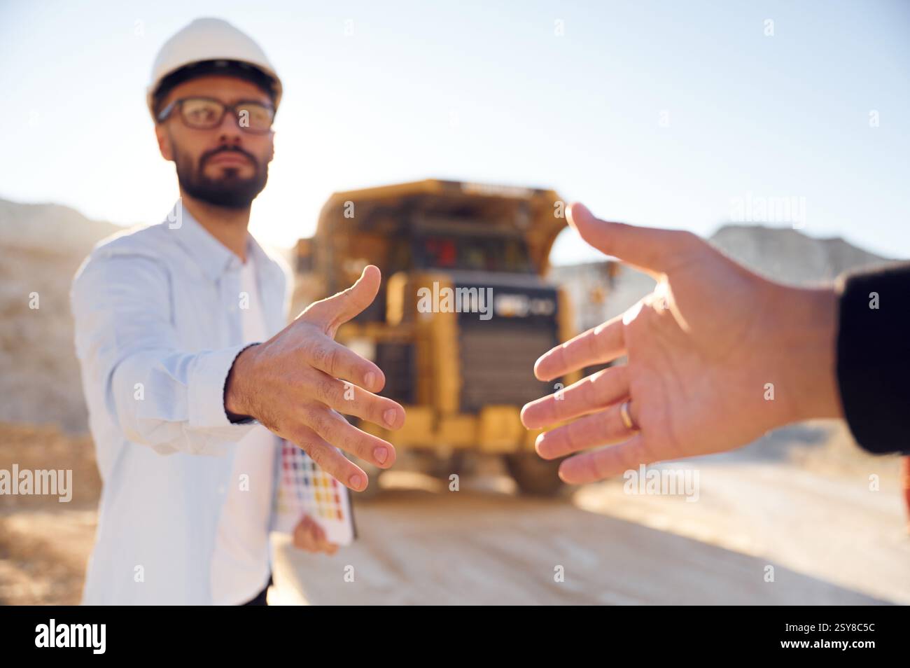 Giving a hand. Making a deal. Man in uniform is working in the quarry ...