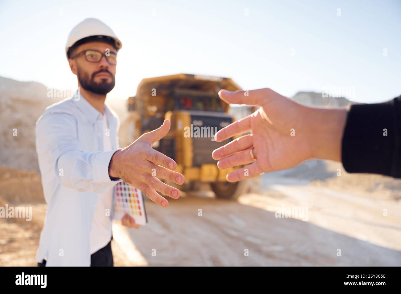 Giving a hand. Making a deal. Man in uniform is working in the quarry ...