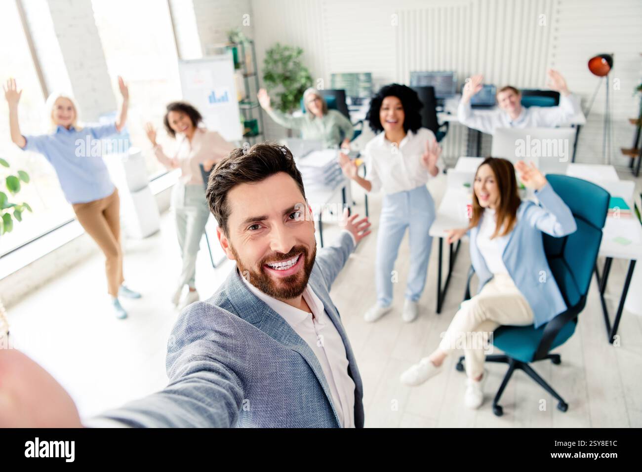 Diverse group of enthusiastic office workers cheering together in a ...