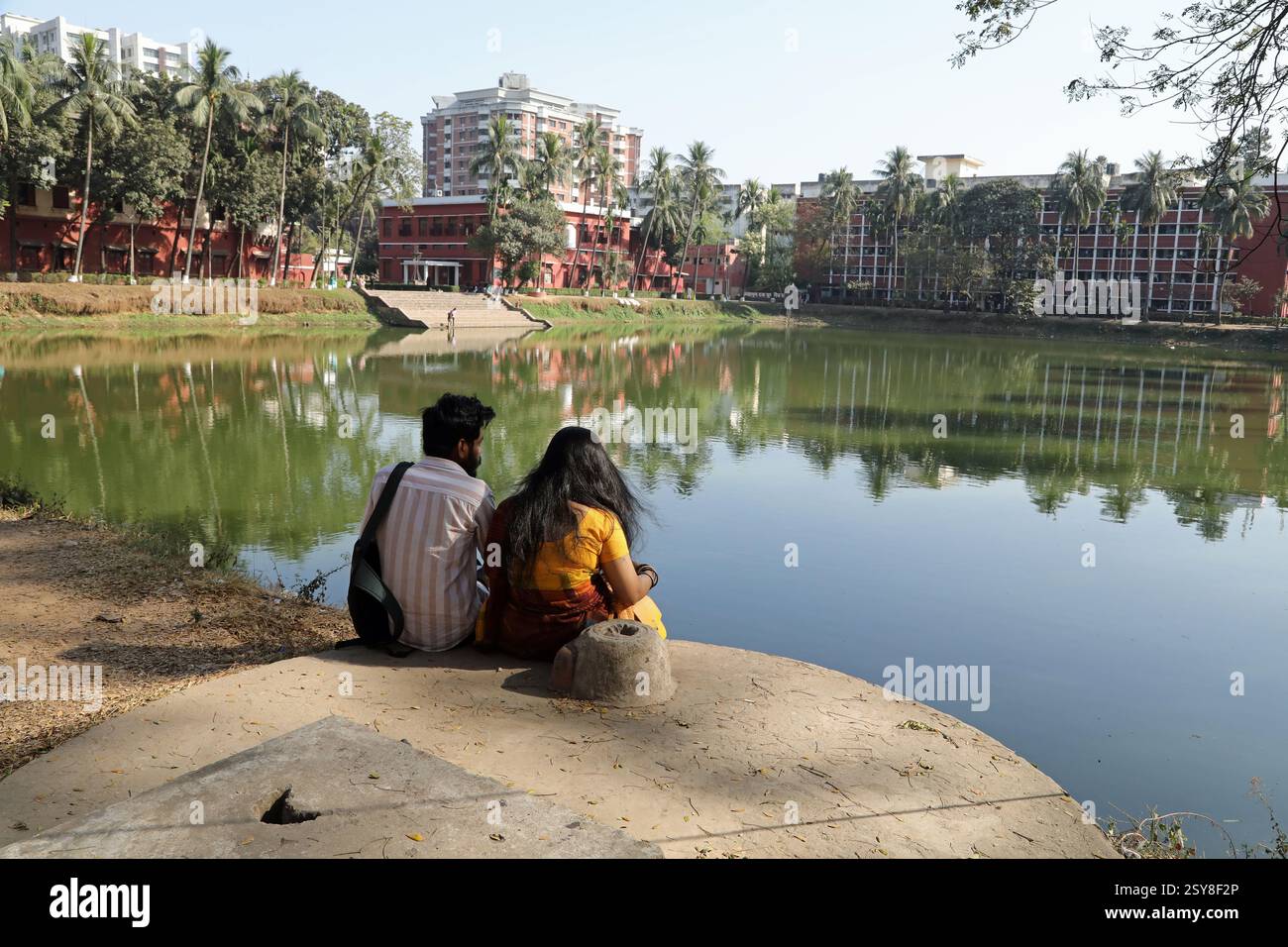 Students sitting by the pond in the grounds of Dhaka University in Bangladesh Stock Photo - Alamy