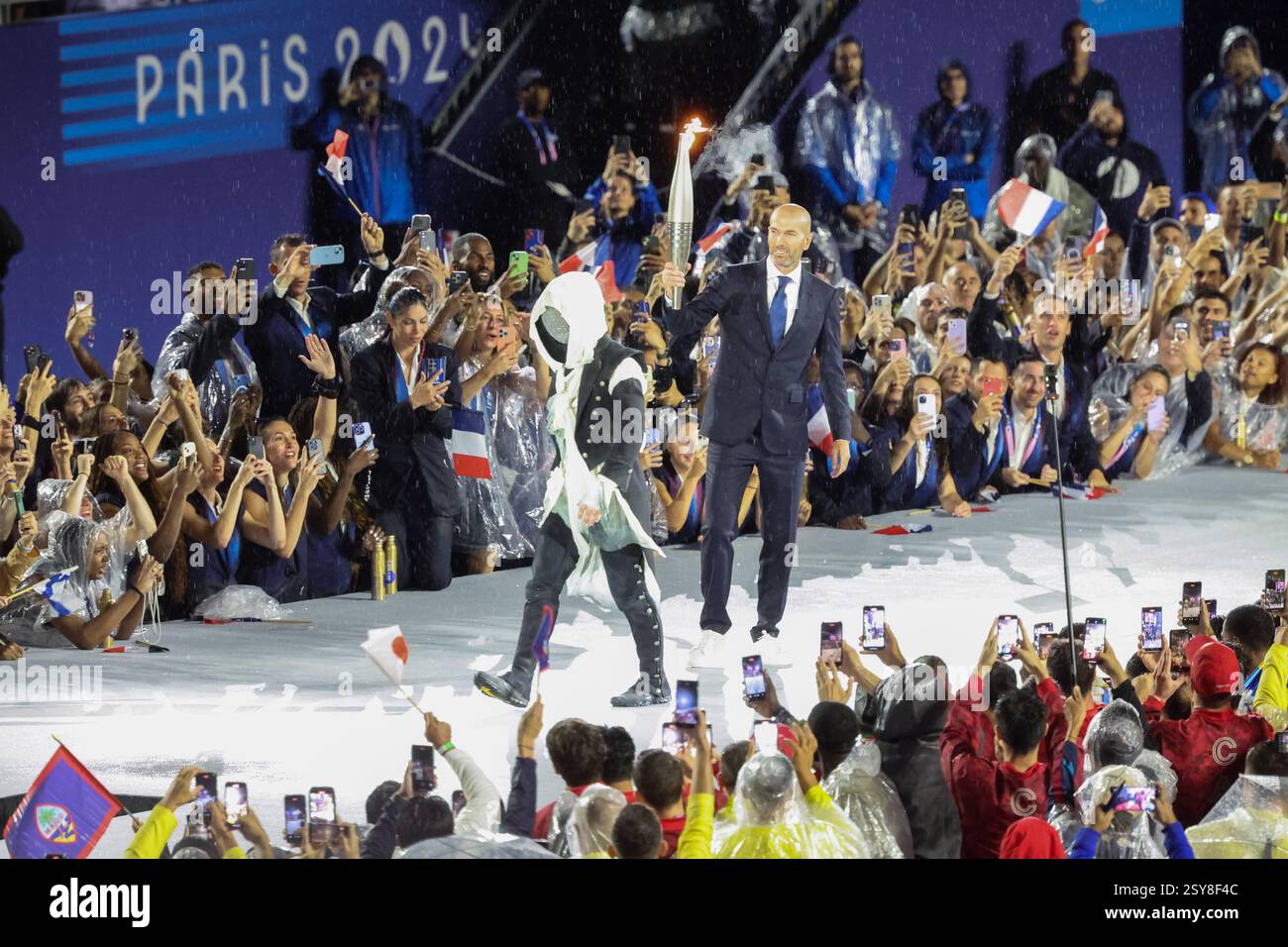 July 26th, 2024 - Paris, France: the masked torchbearer gives the ...