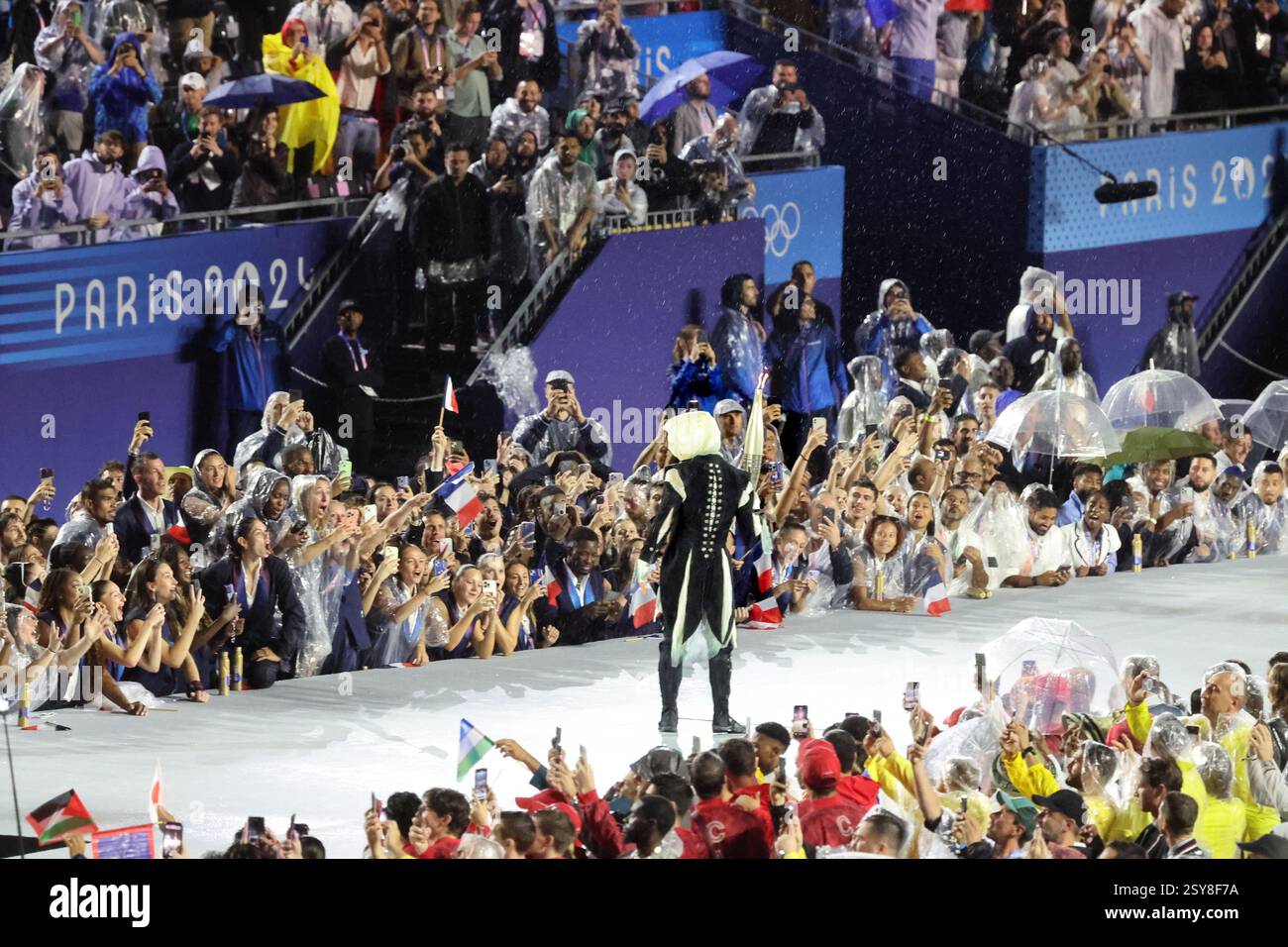 July 26th, 2024 - Paris, France: The masked torchbearer appears at the ...