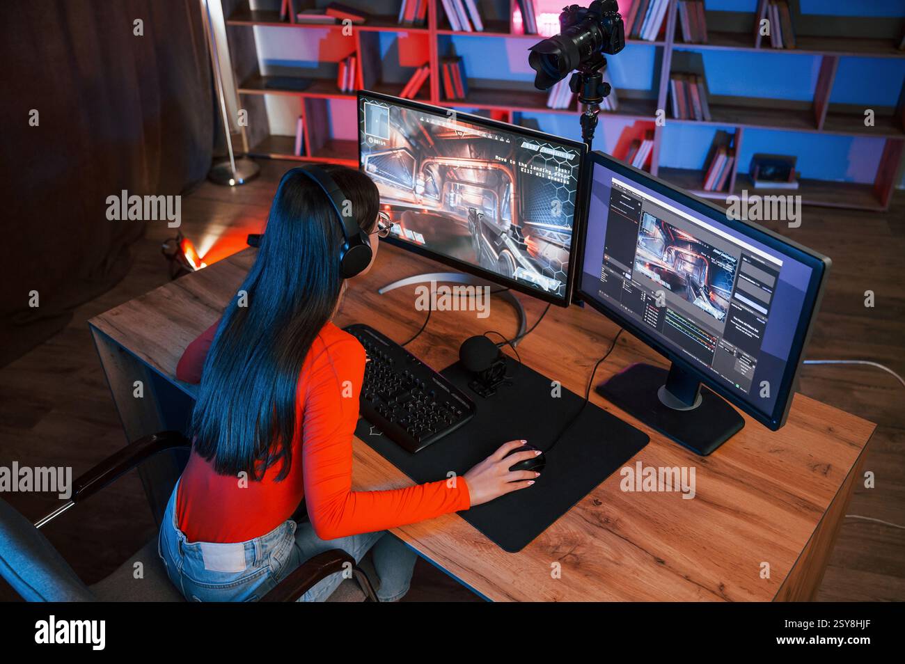 Focused on the game process. Young beautiful streamer is indoors with ...