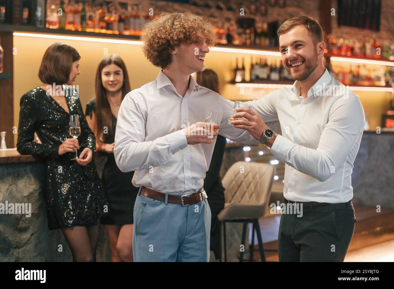 Two men are standing together in formal clothes on the party event ...