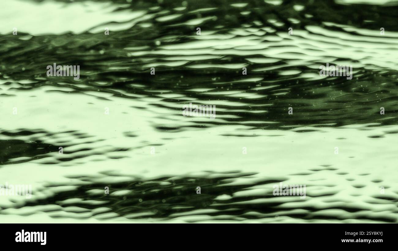 Abstract green water surface with gentle ripples and light reflections ...