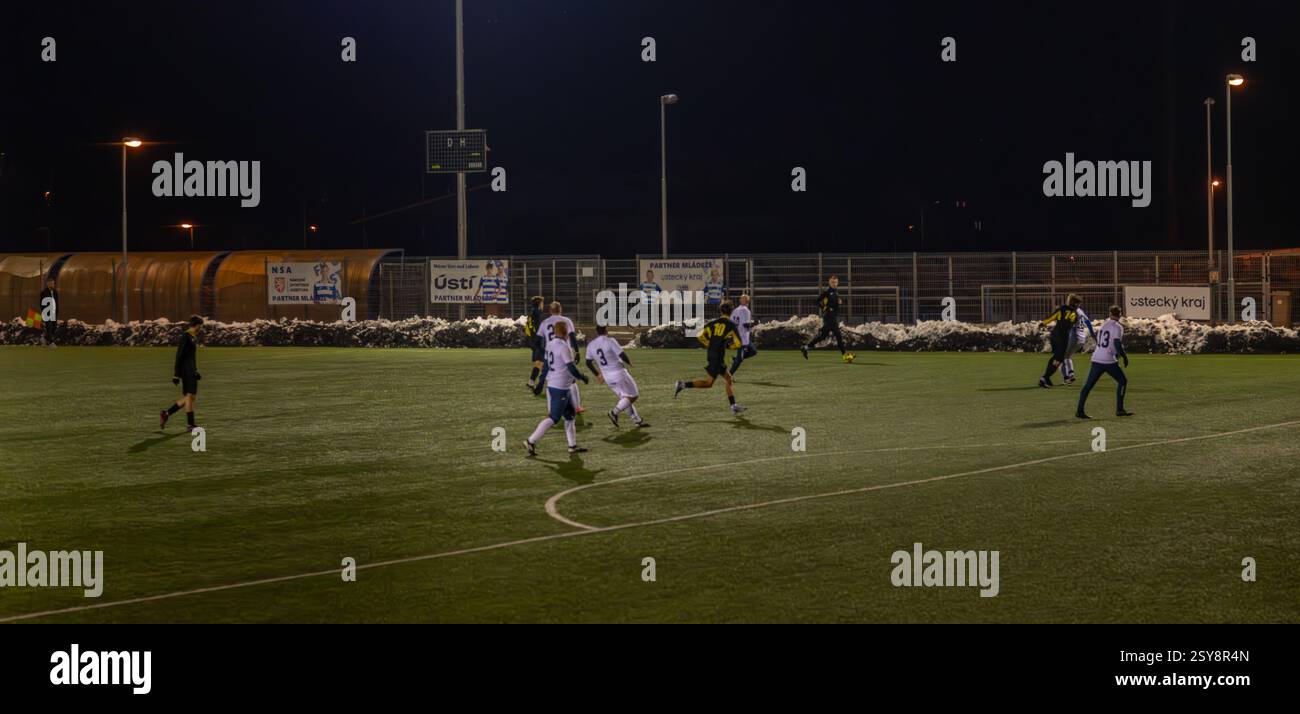 Football match in dark evening with artificial lighting in stadium in ...