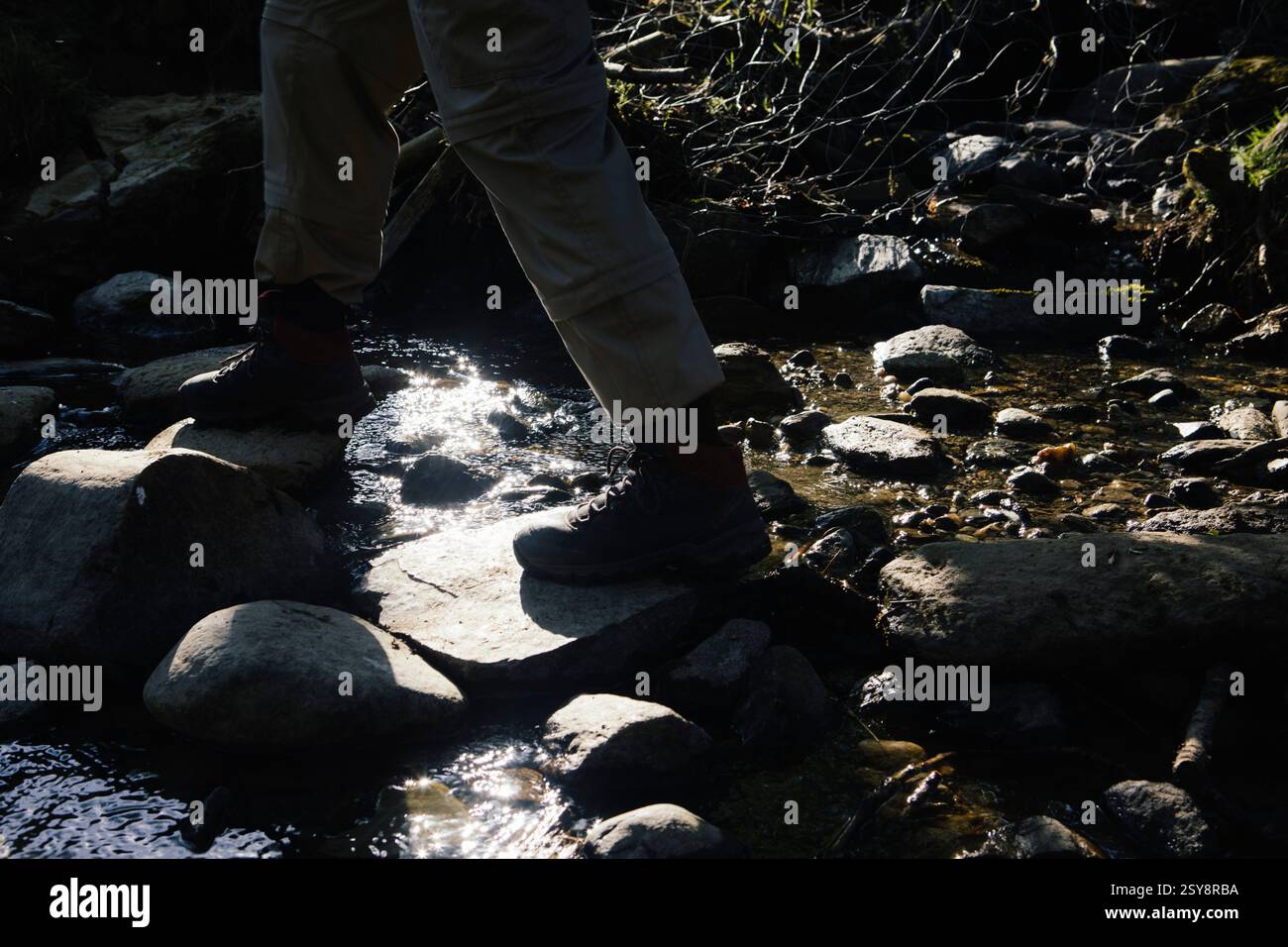 walking boots crossing stepping stones in river Stock Photo - Alamy