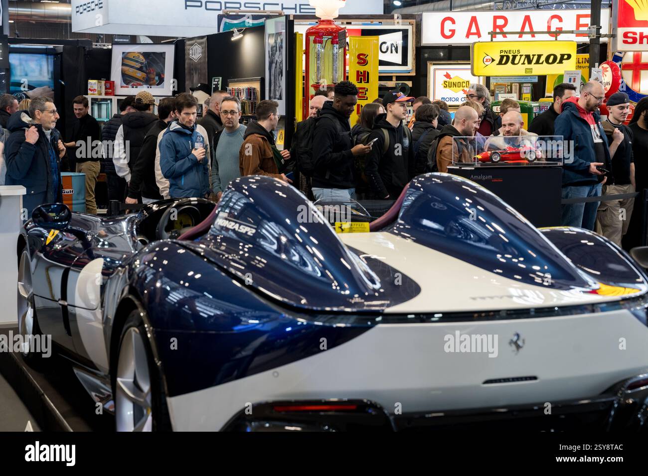 Car enthusiasts gather around a stunning supercar at an automotive ...