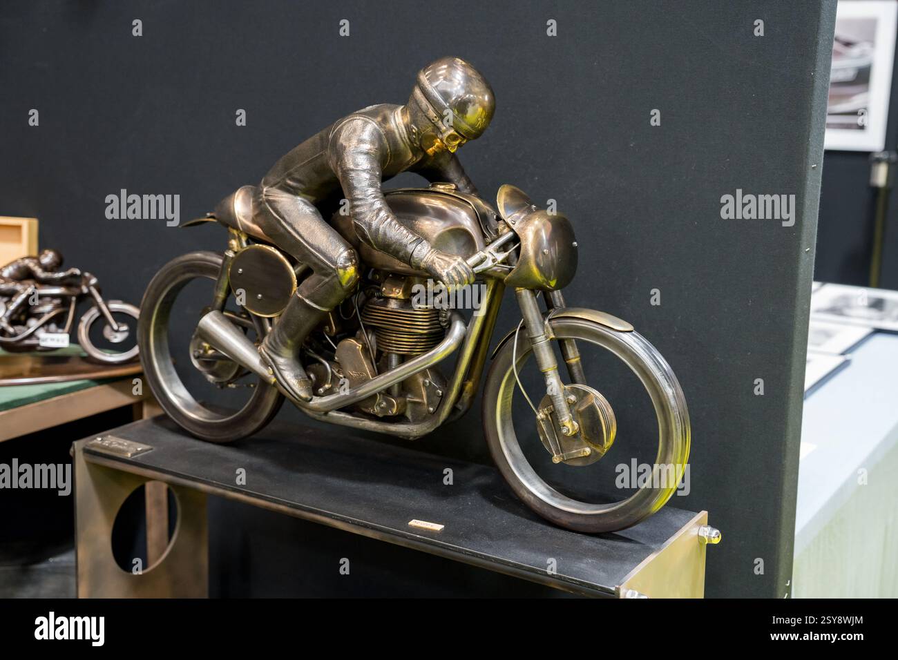 Bronze sculpture of a classic motorcycle racer captured in dynamic ...