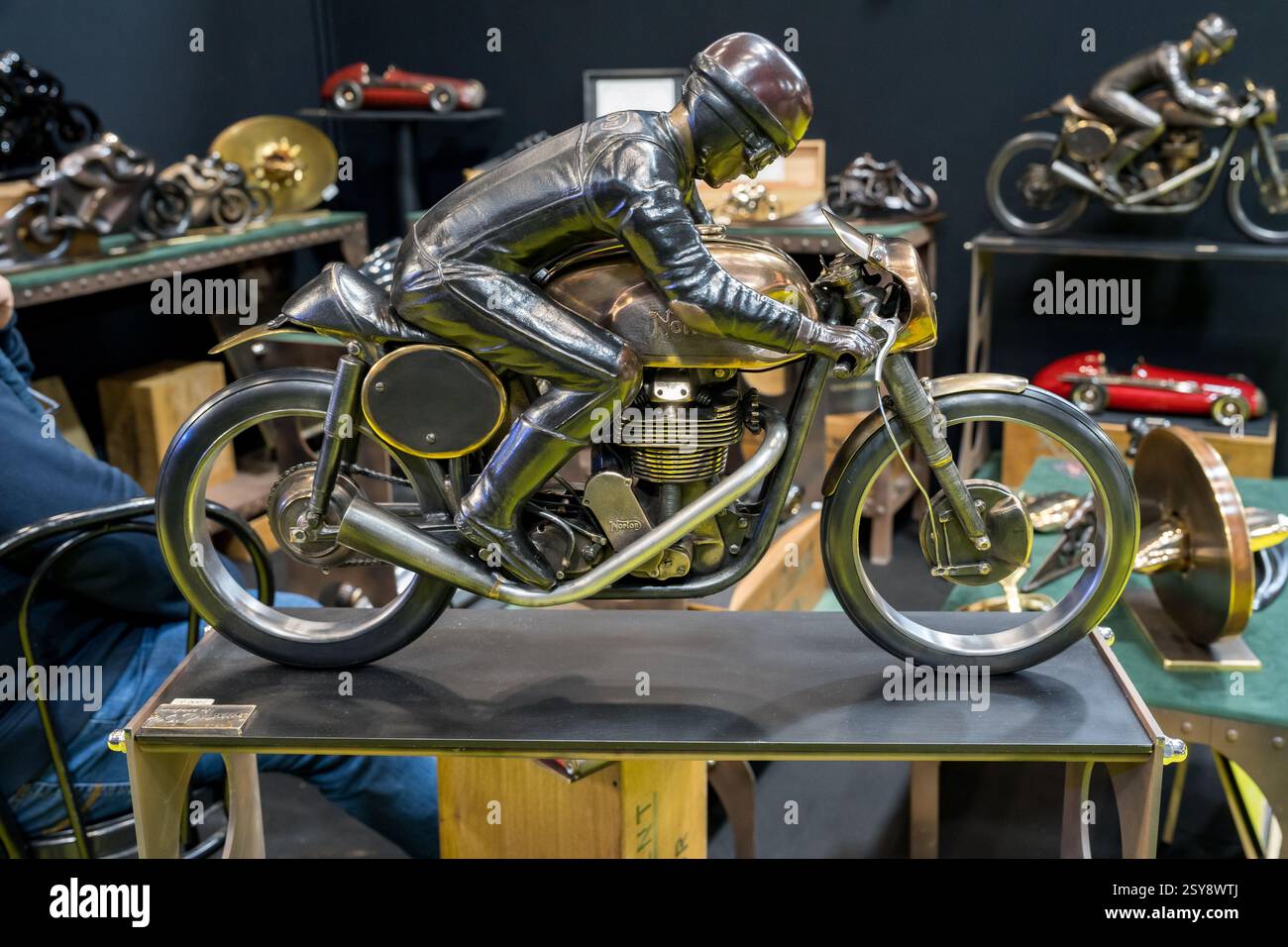Stunning metallic sculpture of a motorcycle racer in dynamic pose ...