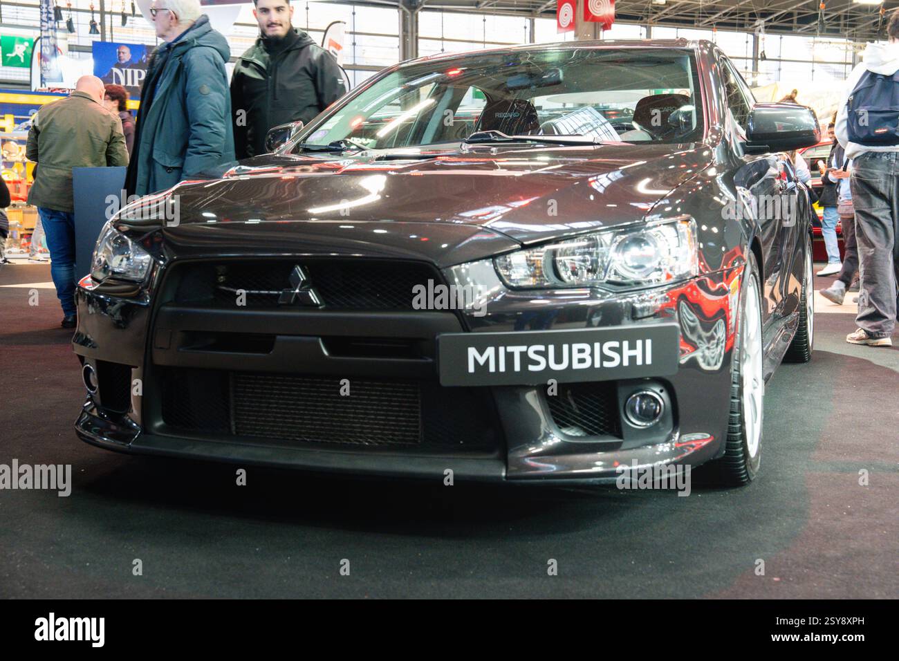 Elegant automotive showcase featuring a sleek Mitsubishi at a vibrant ...