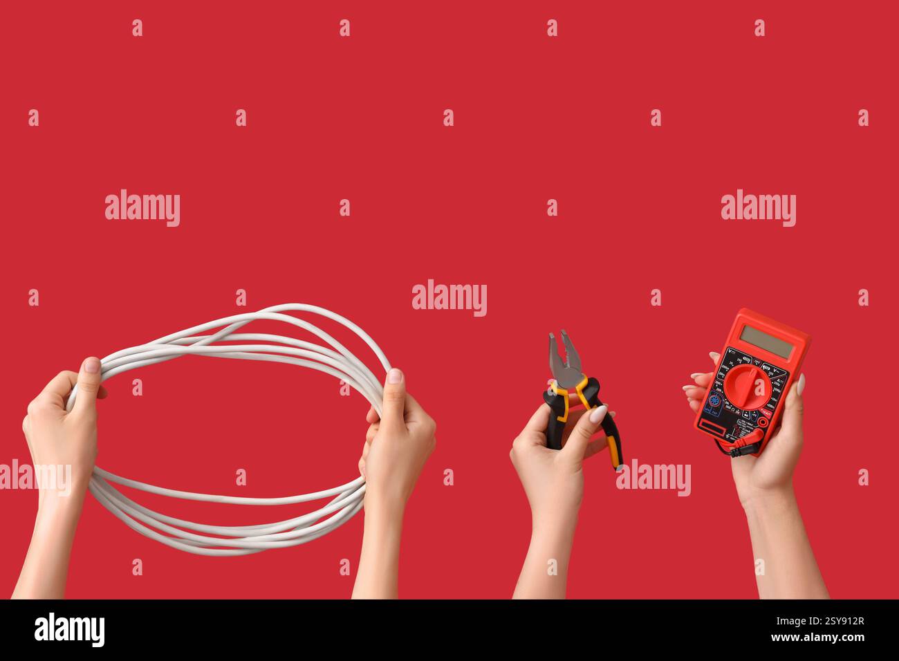 Electrician hands with tools and wire on red background Stock Photo - Alamy