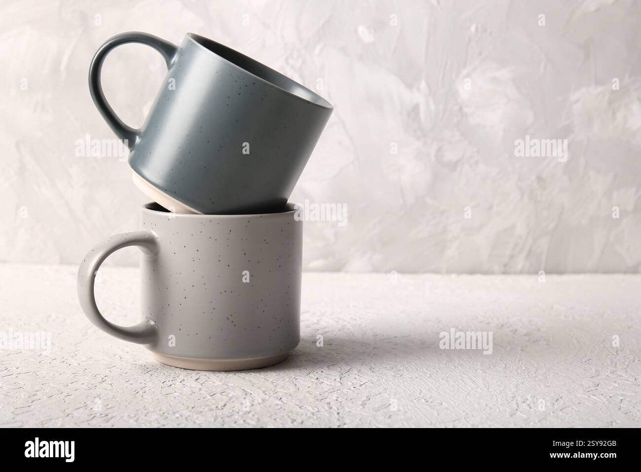 Ceramic mugs on table near white wall Stock Photo - Alamy