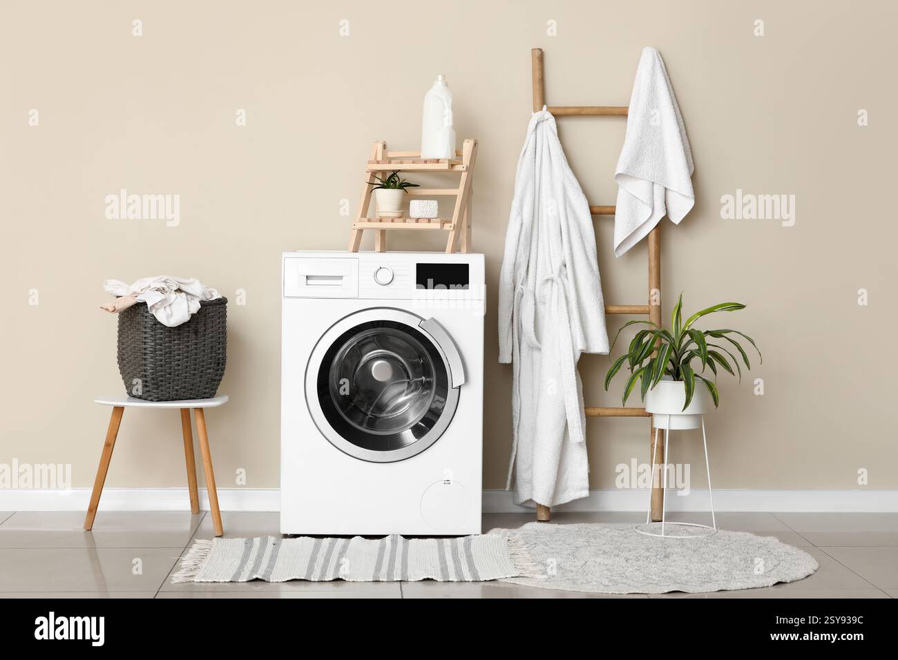 Washing machine, basket with dirty clothes and ladder with robe in ...