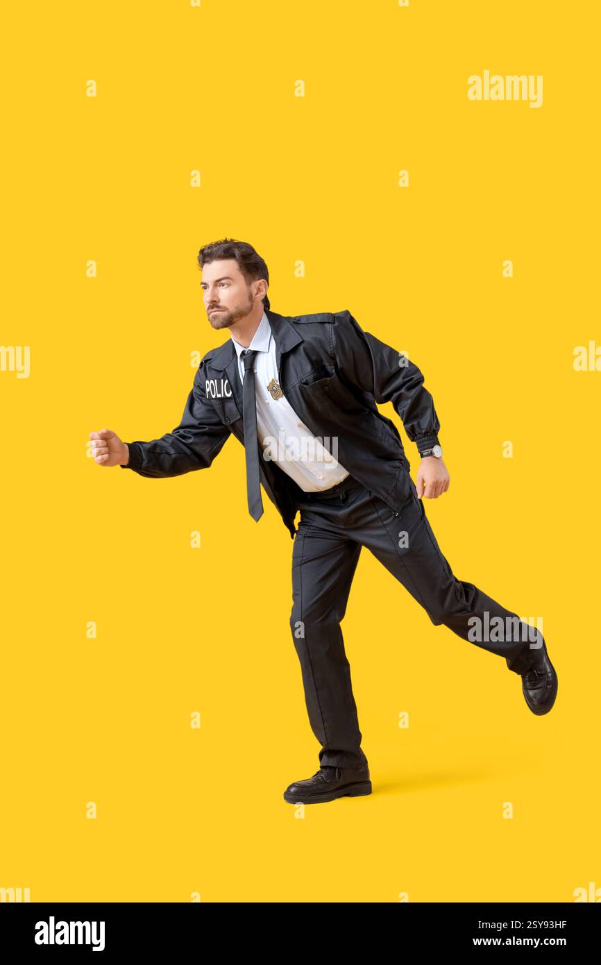 Male police officer with badge running on yellow background Stock Photo ...
