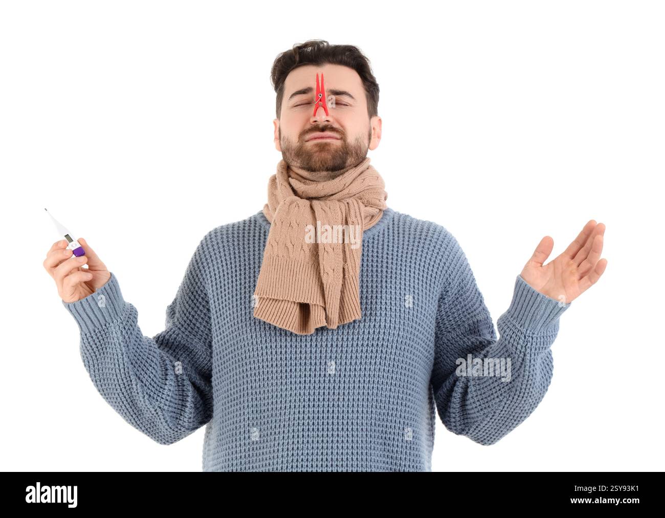 Ill young man with clothespin on his nose and thermometer against white ...