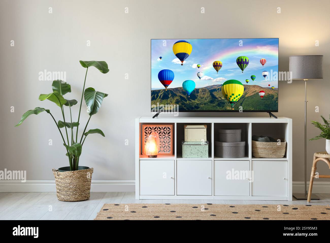 TV set with hot air balloons floating over mountains on screen in room ...