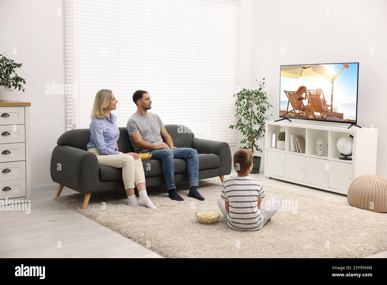 Family watching movie on TV set at home Stock Photo - Alamy