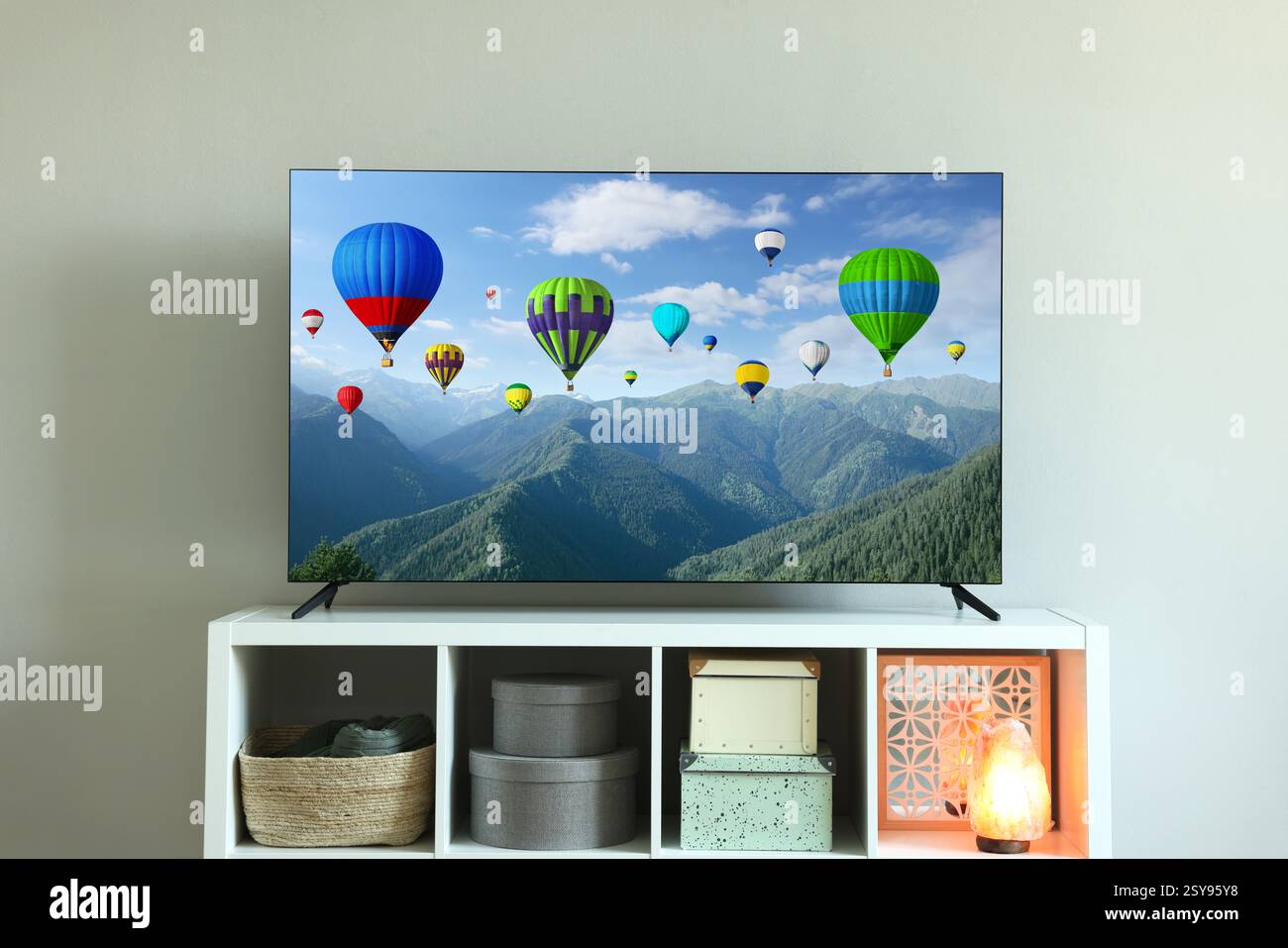 TV set with hot air balloons floating over mountains on screen in room ...