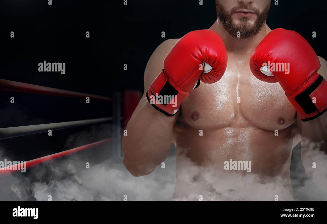 Boxer wearing red gloves on boxing ring in smoke, closeup. Space for ...
