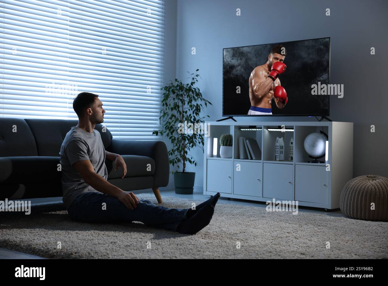 Man watching boxing fight on TV set at home Stock Photo - Alamy