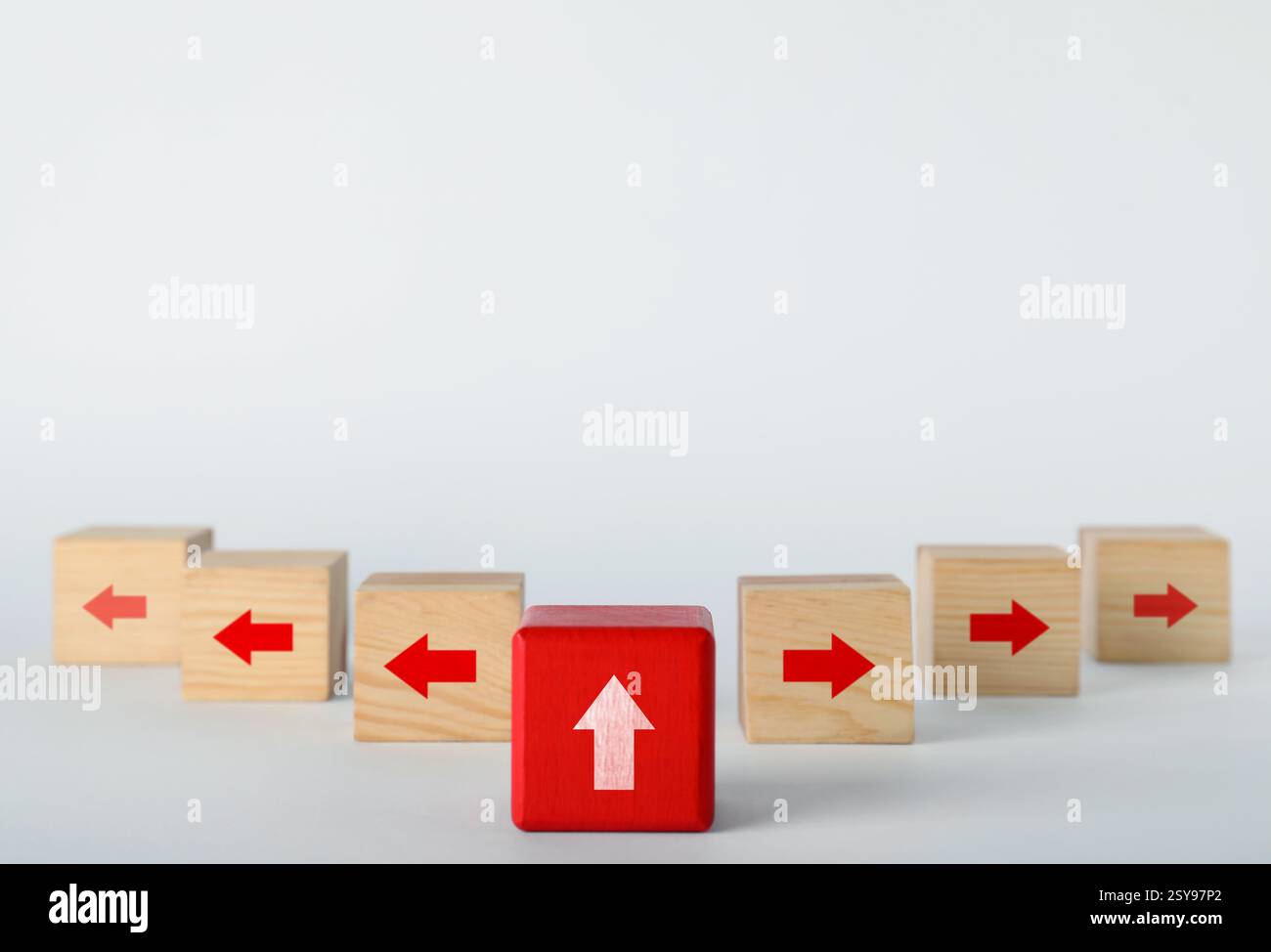 Wooden cubes with arrows pointing in different directions on white ...