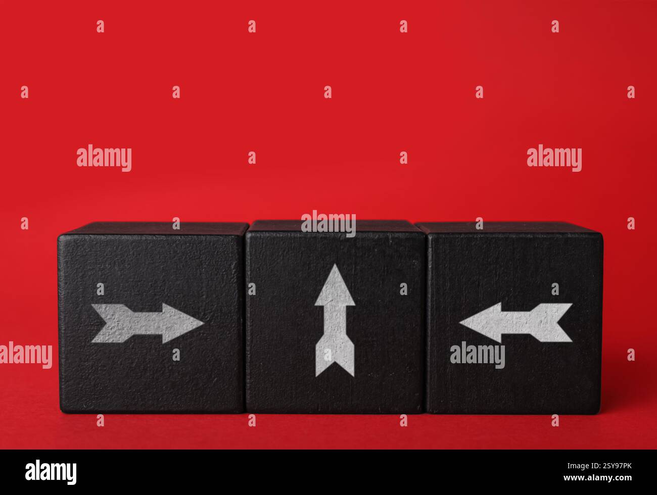 Black cubes with white arrows pointing in different directions on red ...