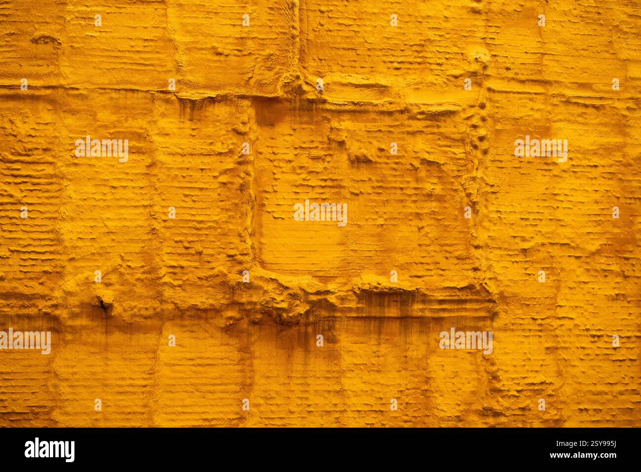 Bright yellow textured wall creates a vibrant backdrop in an urban ...