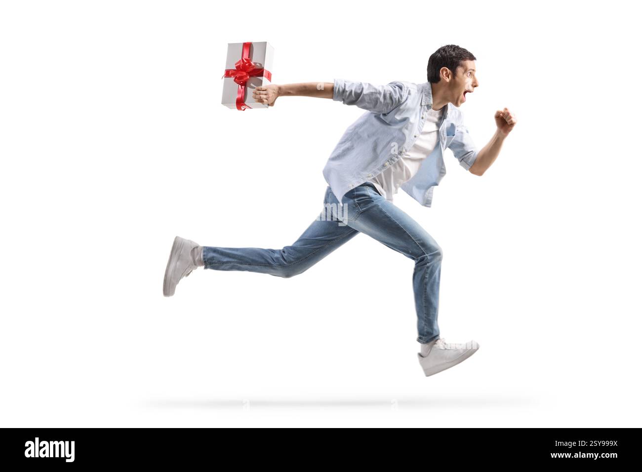 Full length profile shot of a young excited man running with a present ...