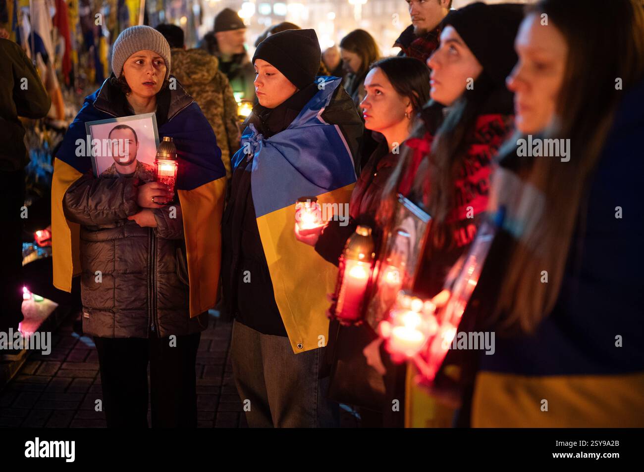 Non Exclusive: People hold lit candles and photos of servicemen during ...