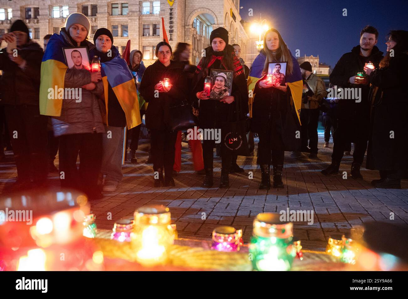 Non Exclusive: People hold lit candles and photos of servicemen during ...