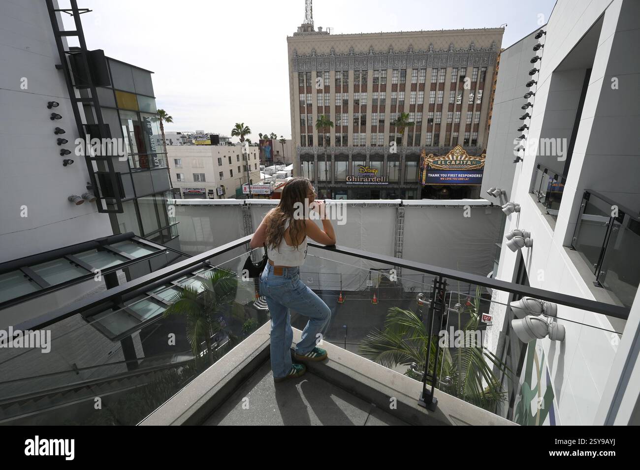 A woman stands above the red carpet tent on Hollywood Blvd. as ...