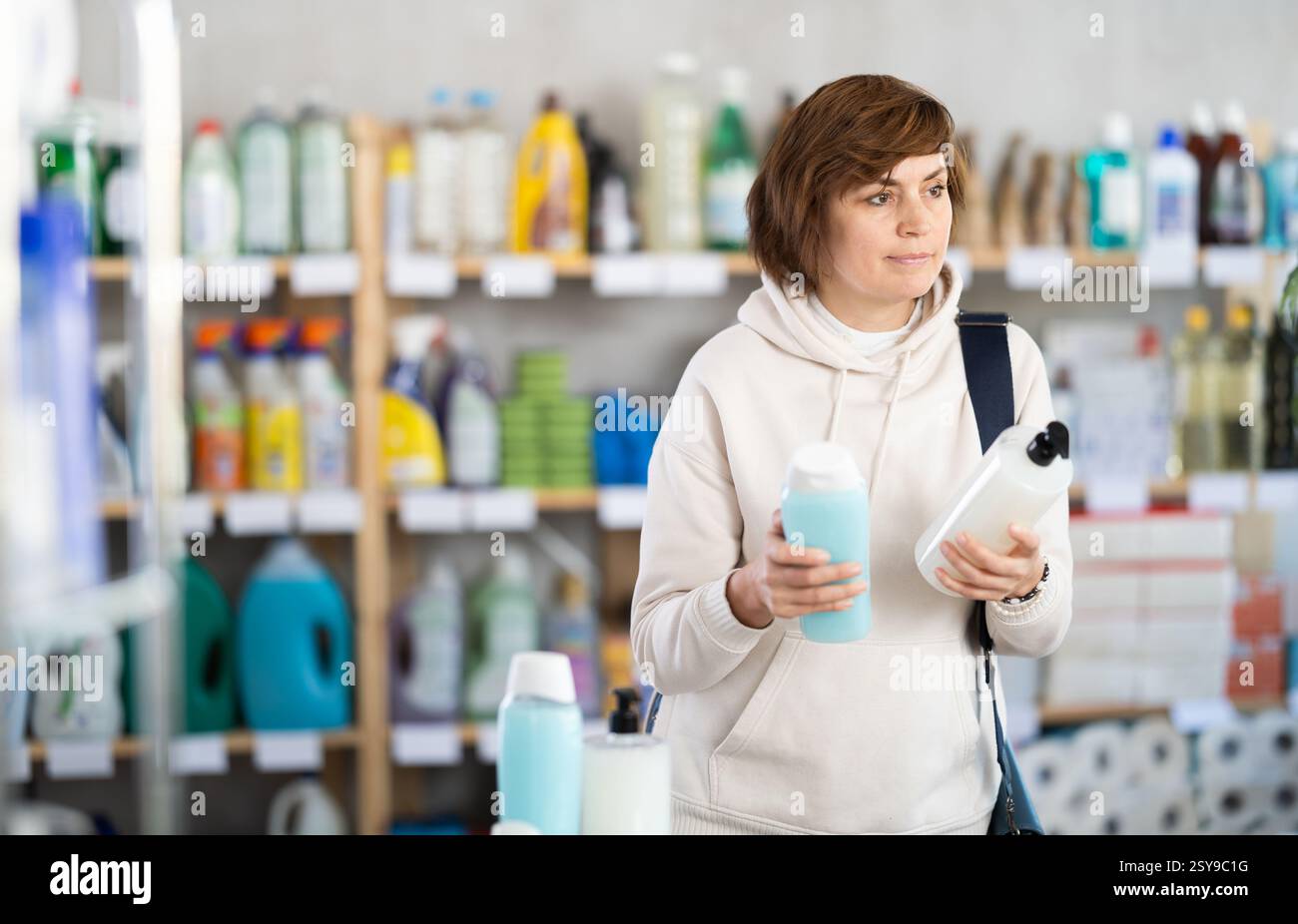 Checking expiration date of shampoo or shower gel - female shopper ...