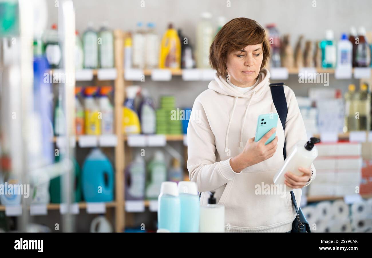 Adult woman scanning qr code for shampoo or shower gel Stock Photo - Alamy