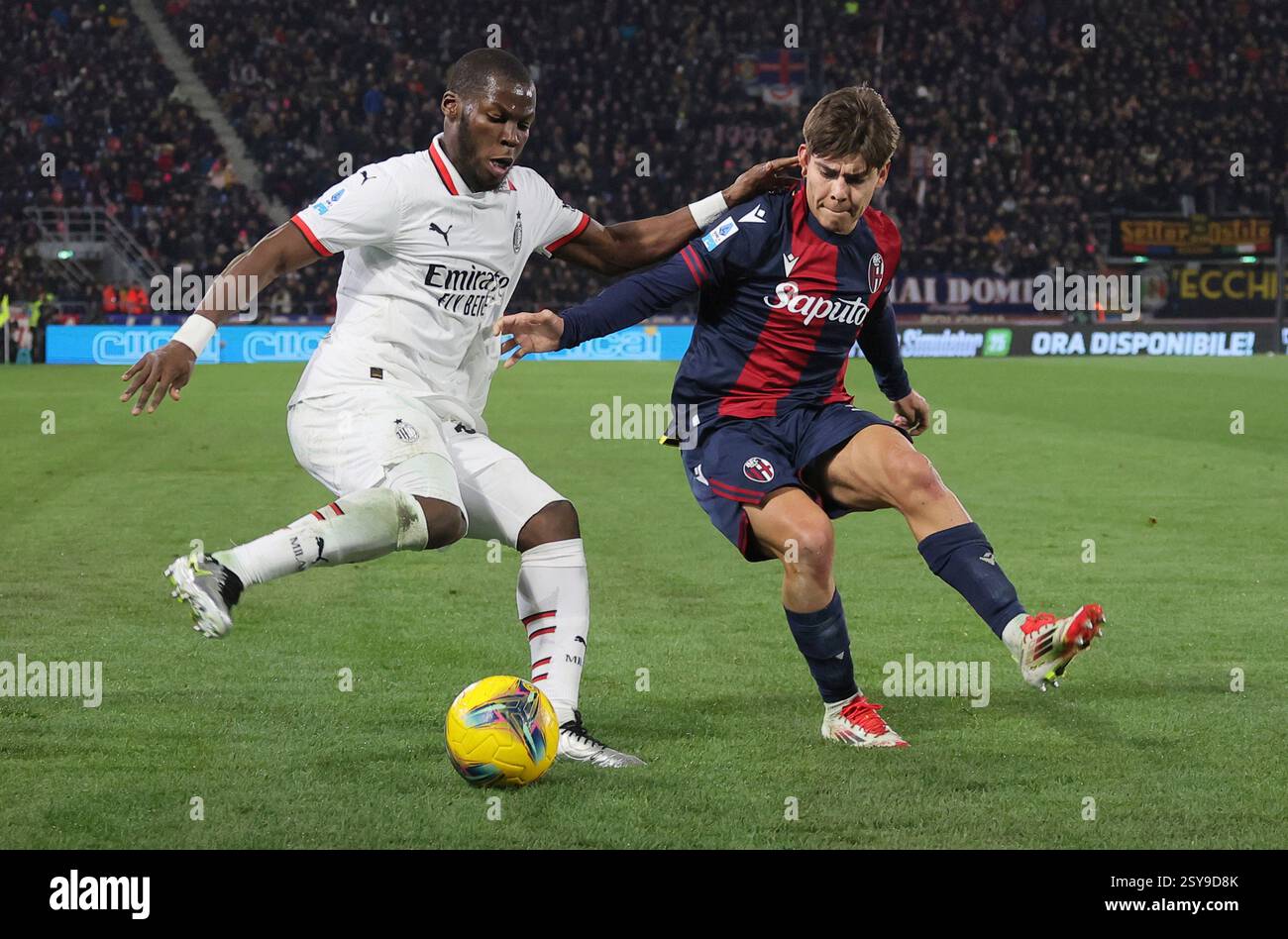 Milan's Yunus Musah, left, and Bologna's Benjamin Dominguez in action ...