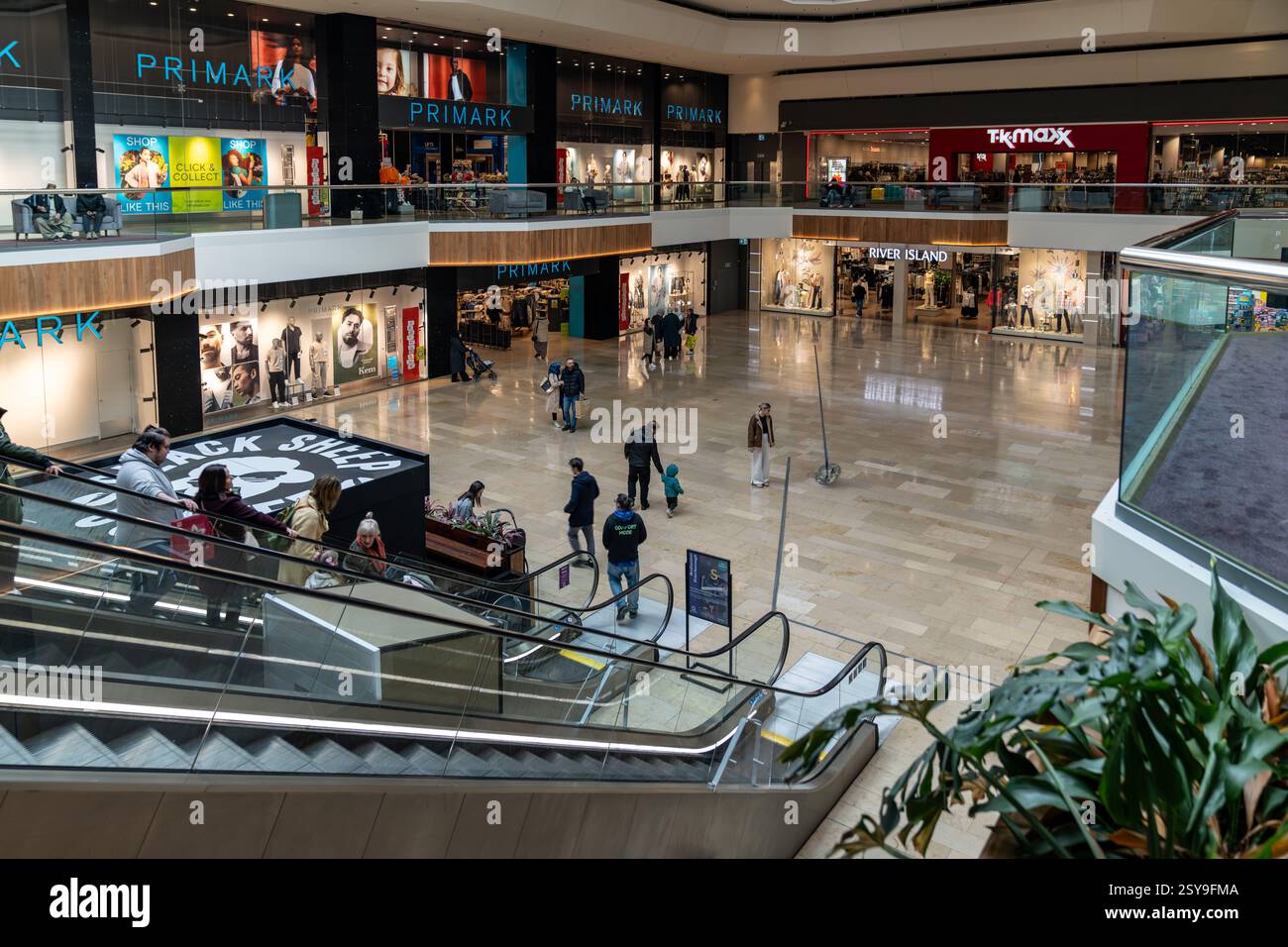 Shoppers going up and down the escalators at Queensgate shopping centre ...