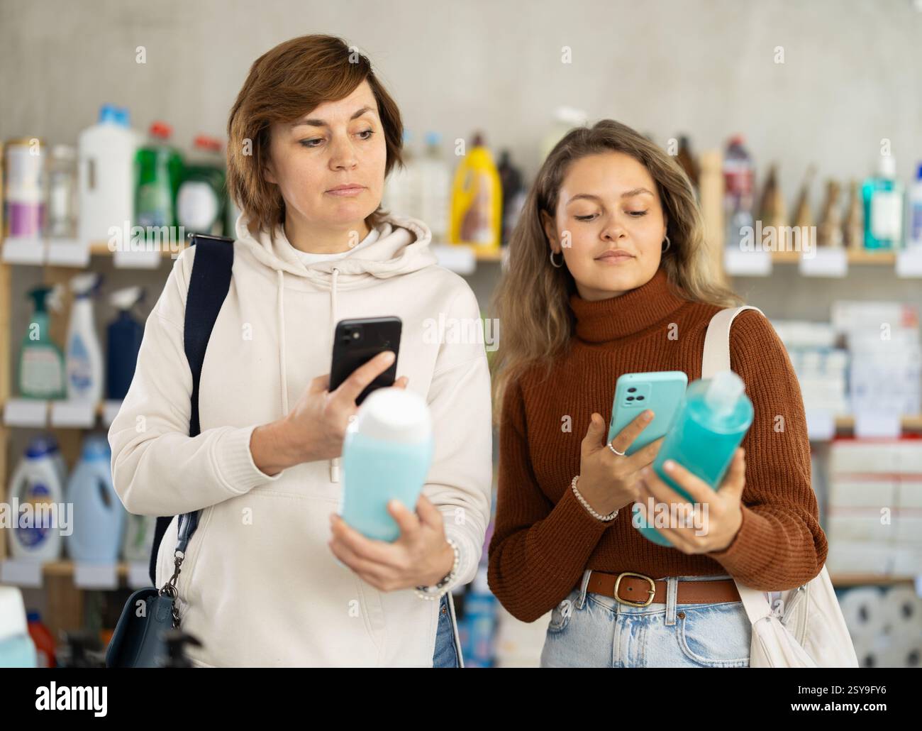 Two women scanning QR-code on shampoo in department store Stock Photo ...