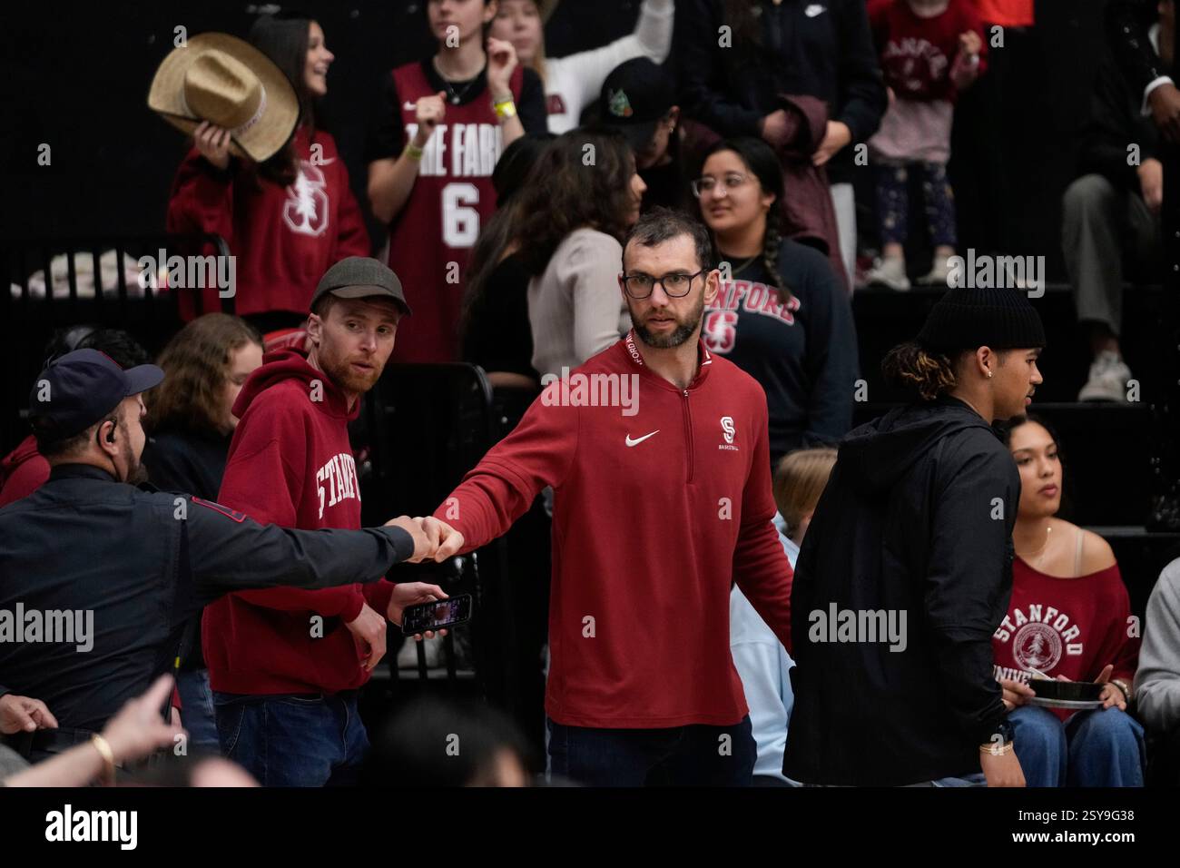 Former football player Andrew Luck, center, is greeted by a security ...