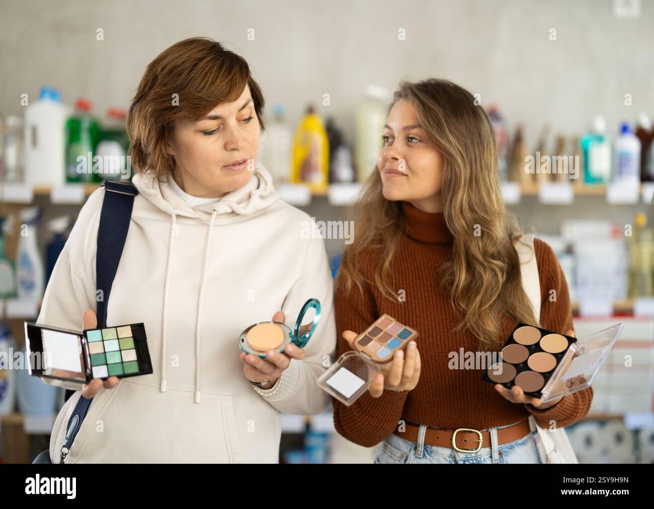 Mother and her adult daughter choose cosmetics together in supermarket ...
