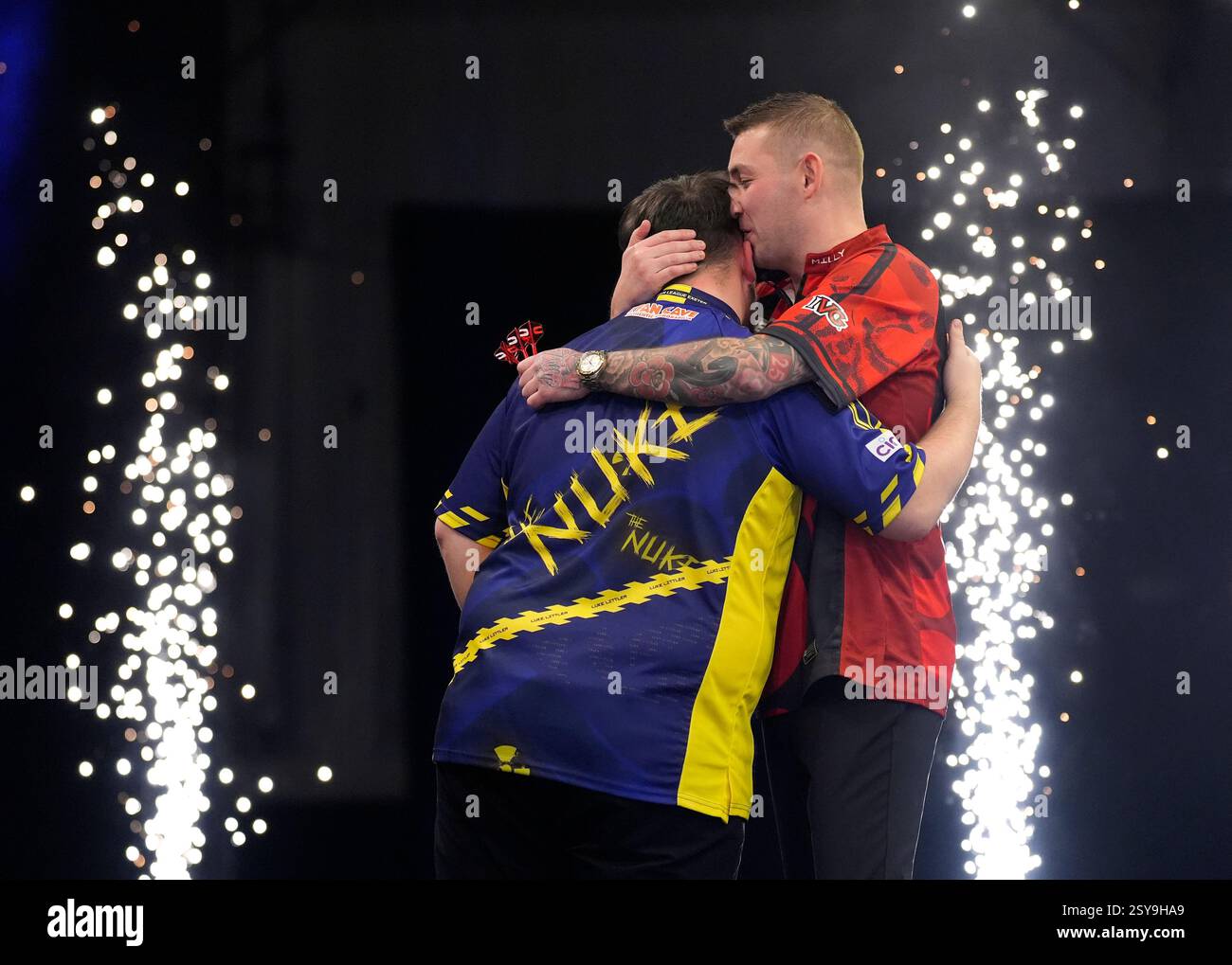 Luke Littler (left) celebrates victory against Nathan Aspinall during ...