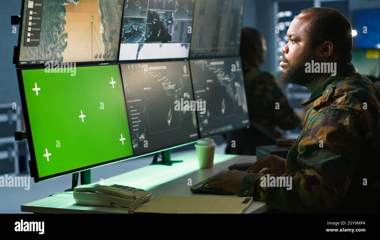 Military agent working in control room, using software on green screen ...