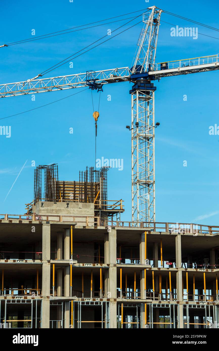 Crane is lifting a large object. The crane is tall and is located near ...