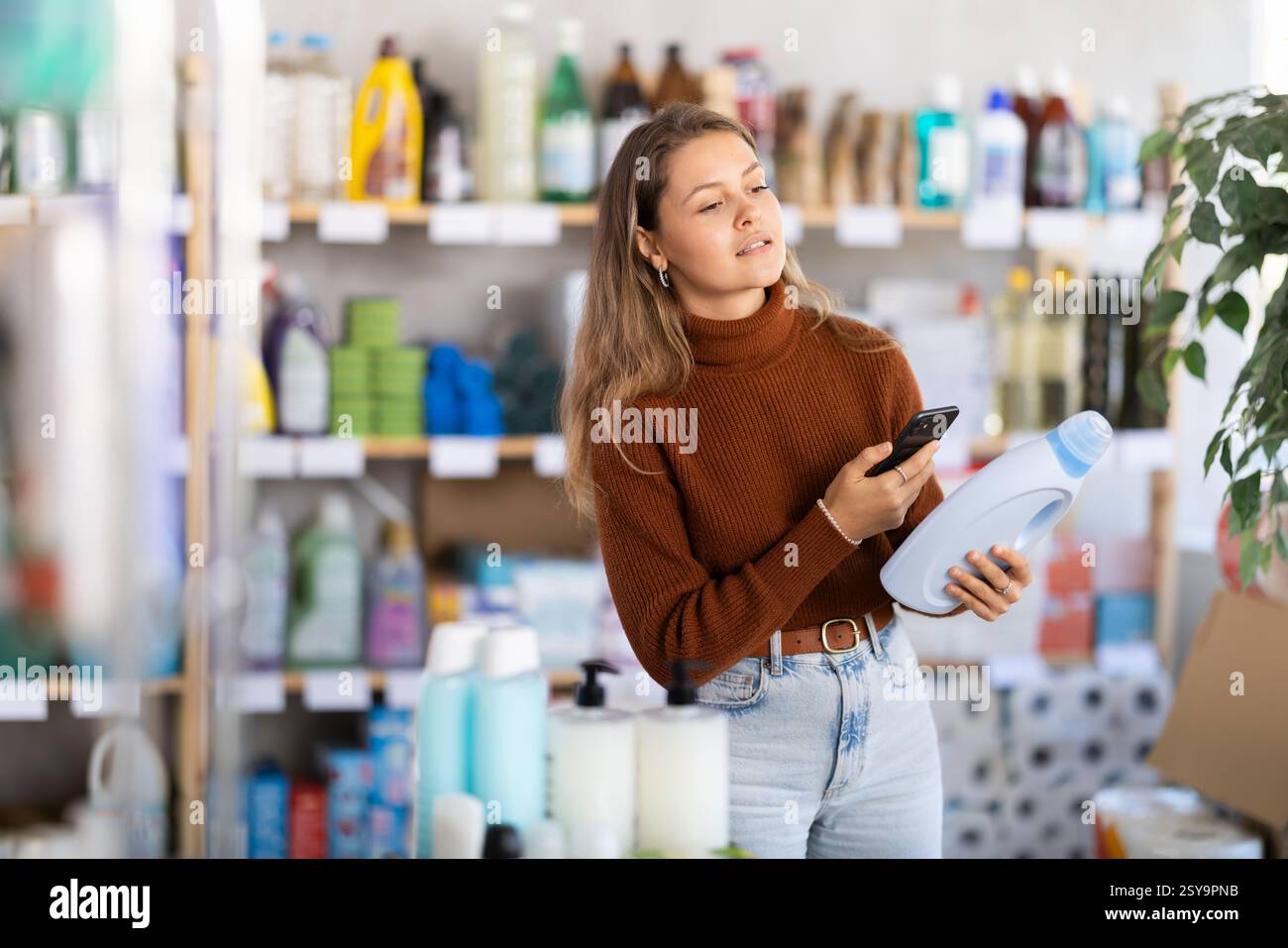 Young woman scanning qr code for detergent Stock Photo - Alamy