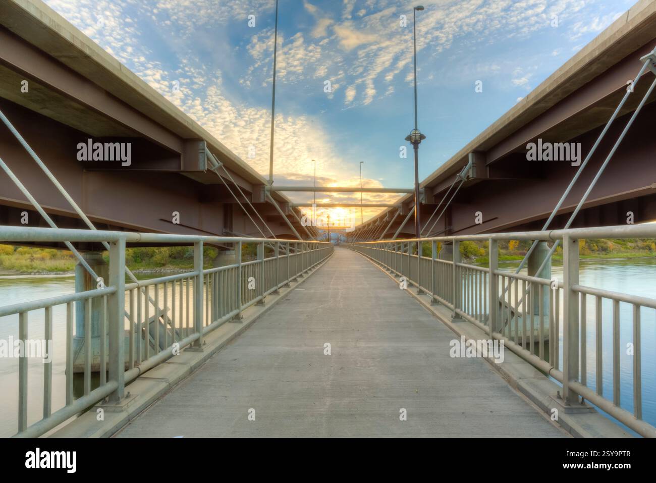 Bridge with a railing on both sides. The bridge is over a body of water ...