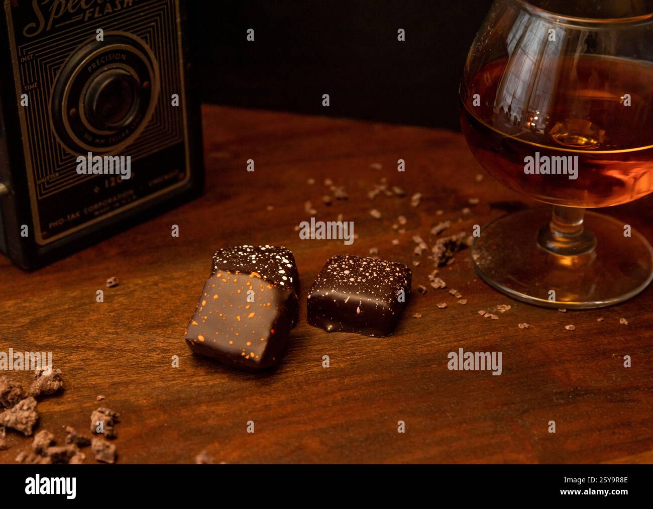 Colorful chocolate caramels with cognac in snifter glass and vintage ...