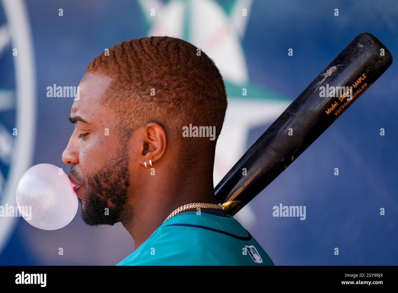 Seattle Mariners designated hitter Victor Robles blows a bubble in the ...