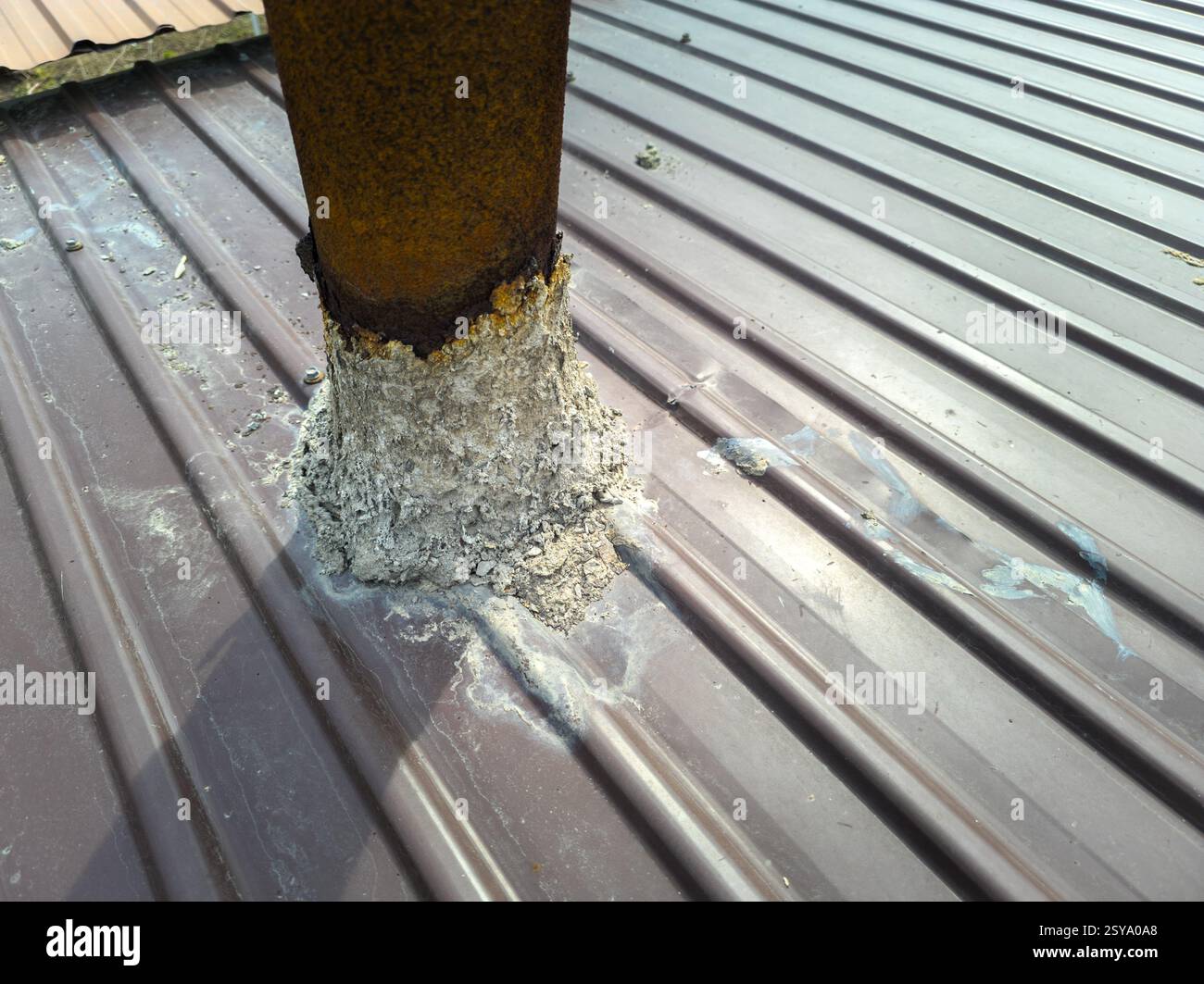 steel stove pipe connection on a metal roof with signs of rust and poor ...